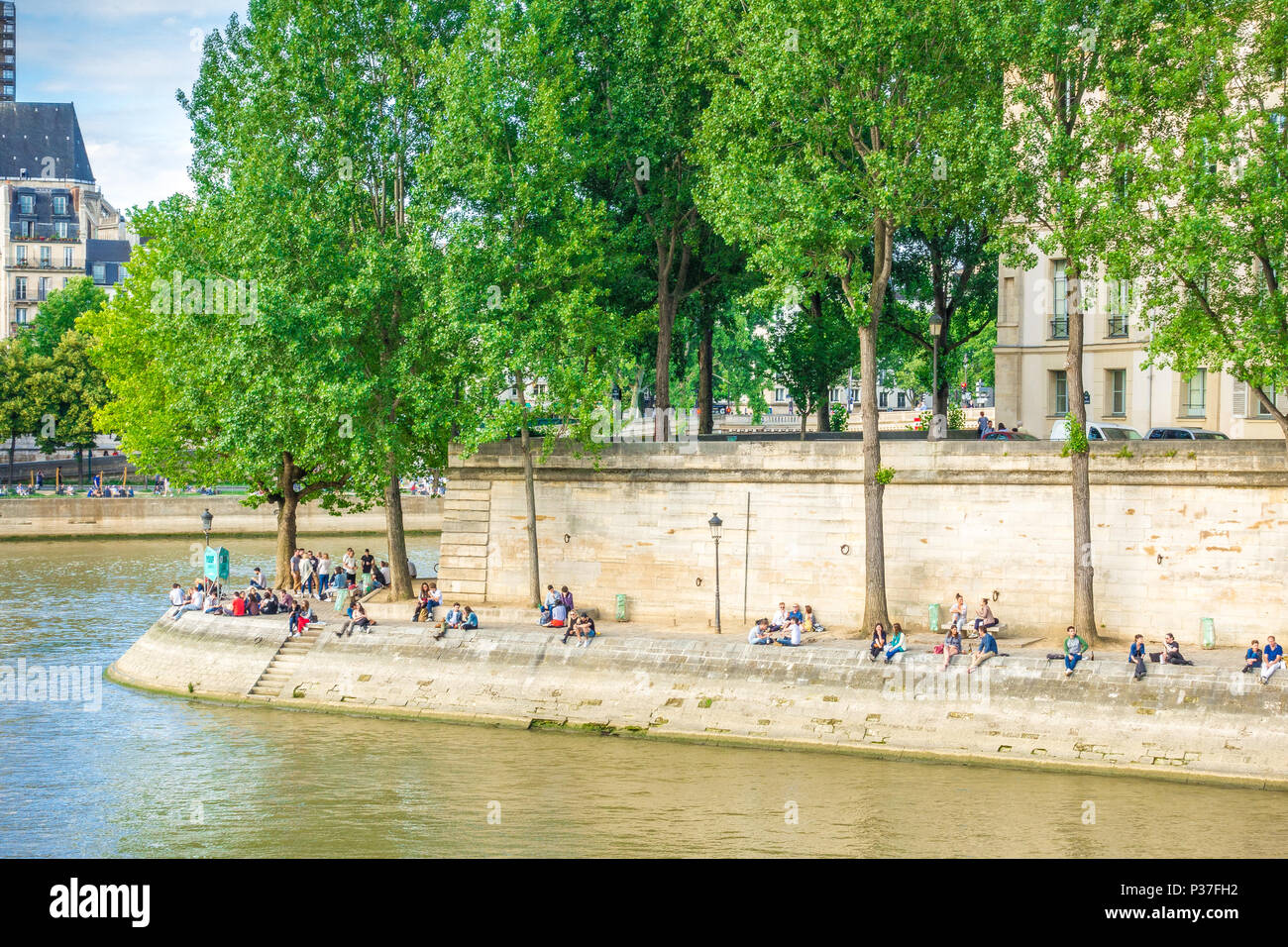 People hang out on the tip of the Île Saint-Louis at Place Louis Aragon ...
