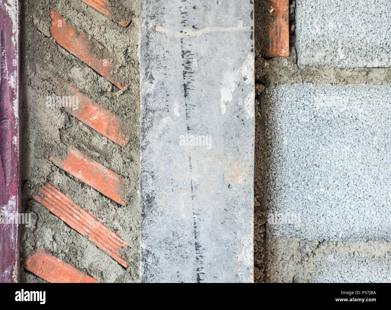 Brick wall layer in the under construction near the concrete pillar of ...