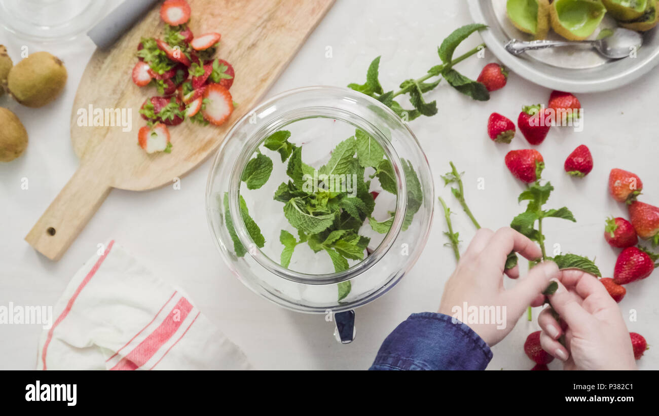 Step by step. Preparing organic infused water in glass beverage drink ...