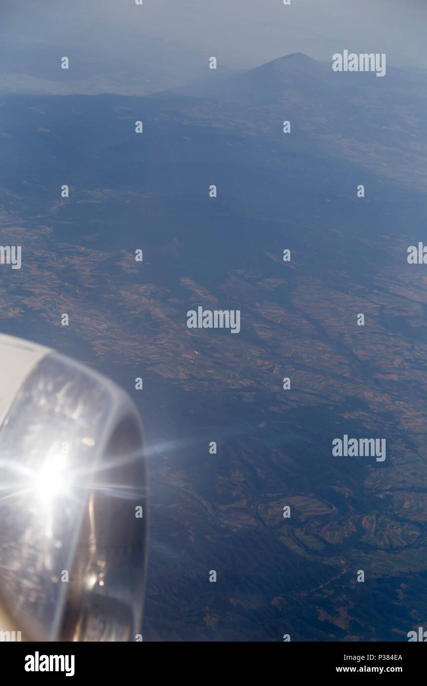 Aerial view from a plane over jet engine on the wing with sun ...