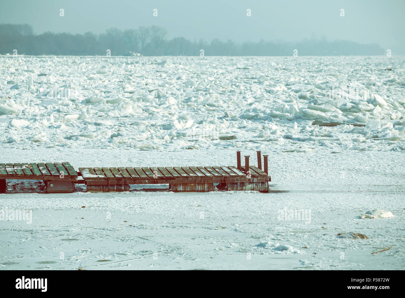 Floating pier damaged by ice at river side in winter time. Vintage ...