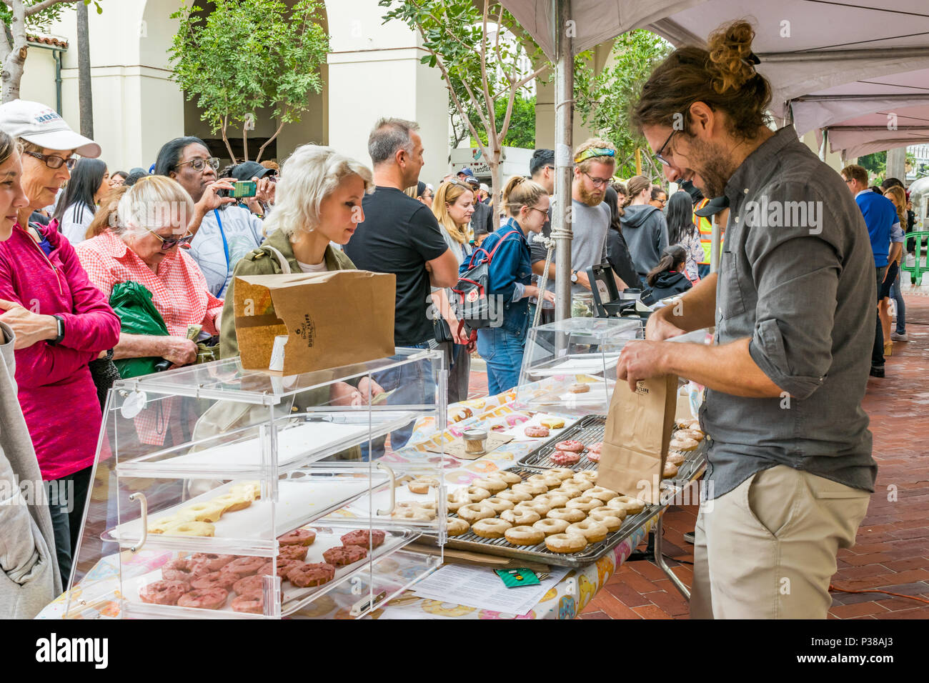 Vendor at Downtown Los Angeles Donut Festival serves vegan doughnuts to ...