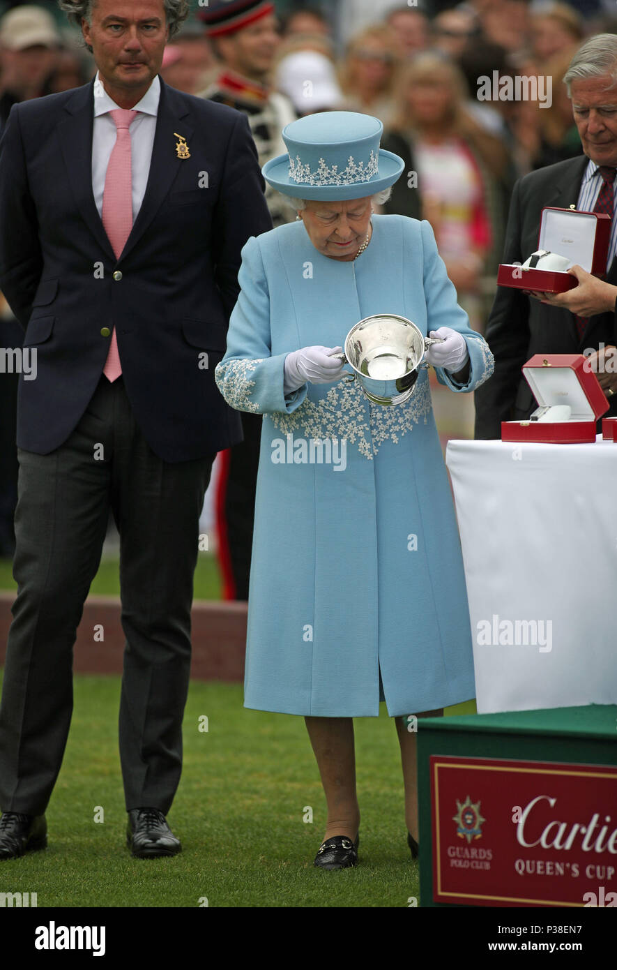 Queen Elizabeth II holds the winner's trophy at the end of the Cartier ...