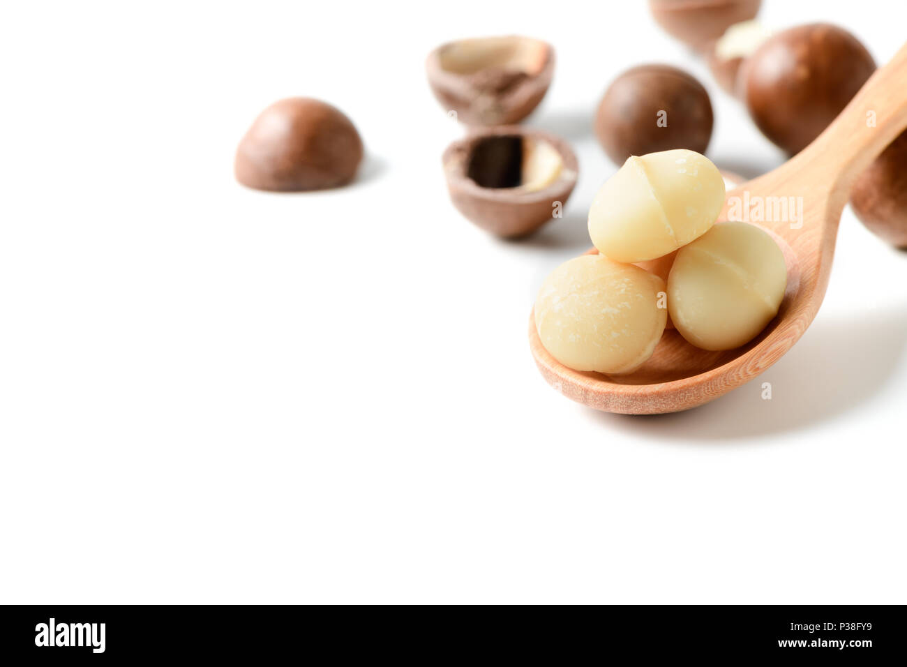 macadamia nuts on wood spoon isolated on white background with copy ...