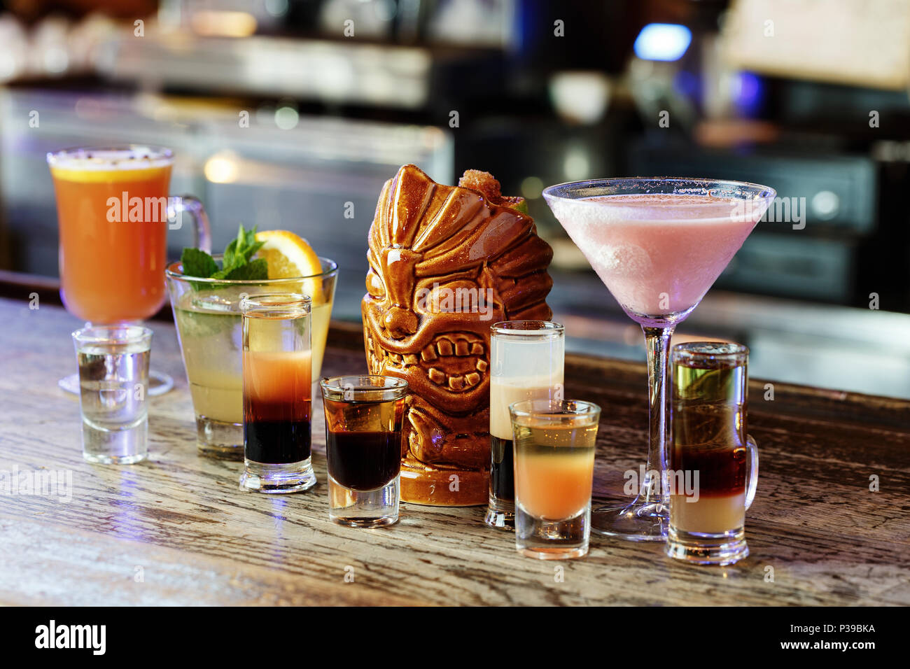 mix of cocktails on the bar, shots and long drinks in a glass of teak ...