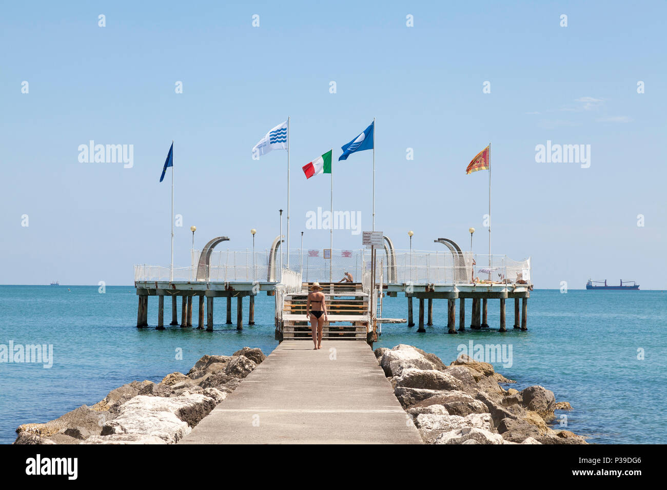 People sunbathing on a pier or deck overlooking the Adriatic, Lido di ...
