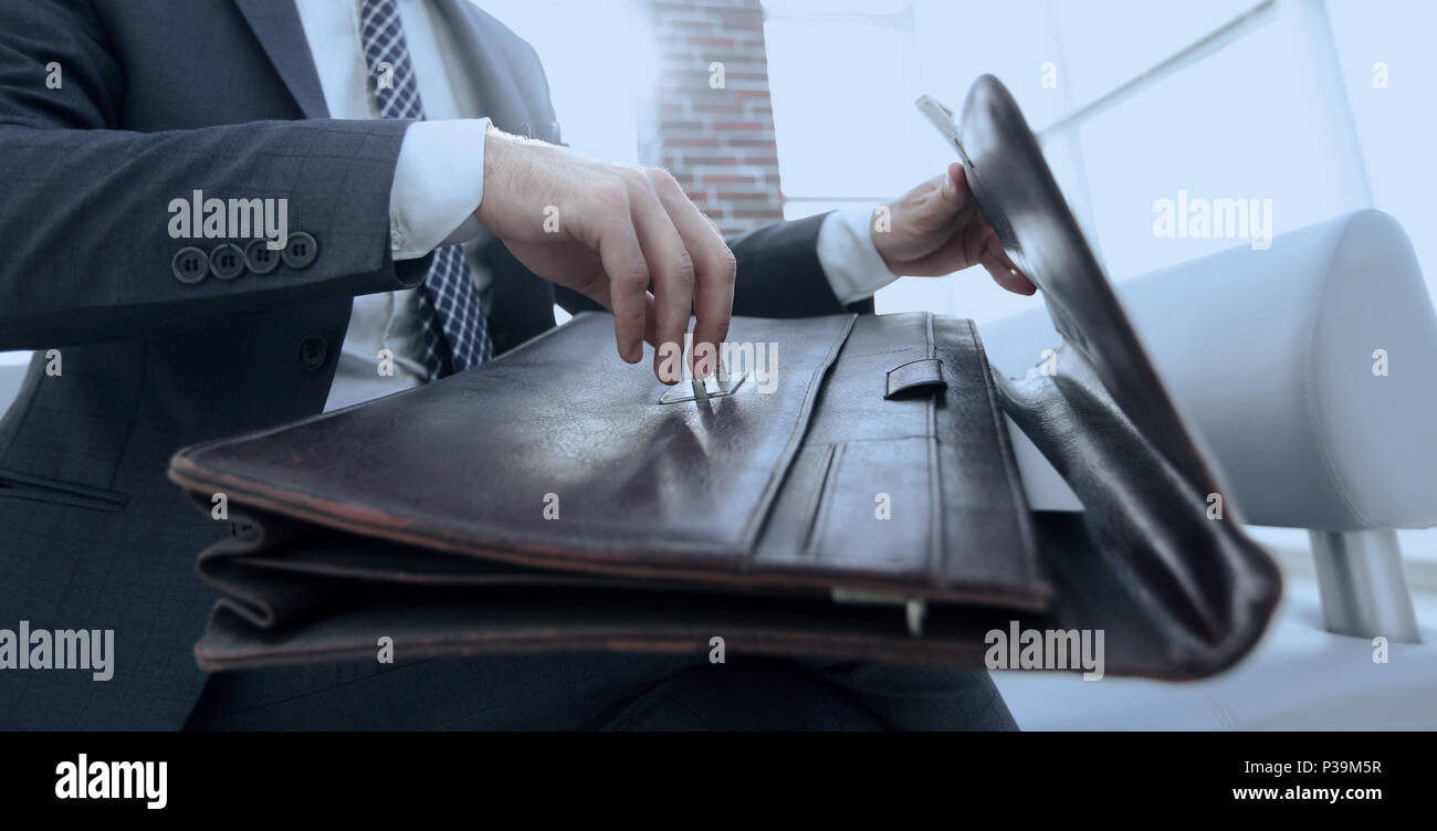businessman's hand with suitecase in a modern office Stock Photo - Alamy