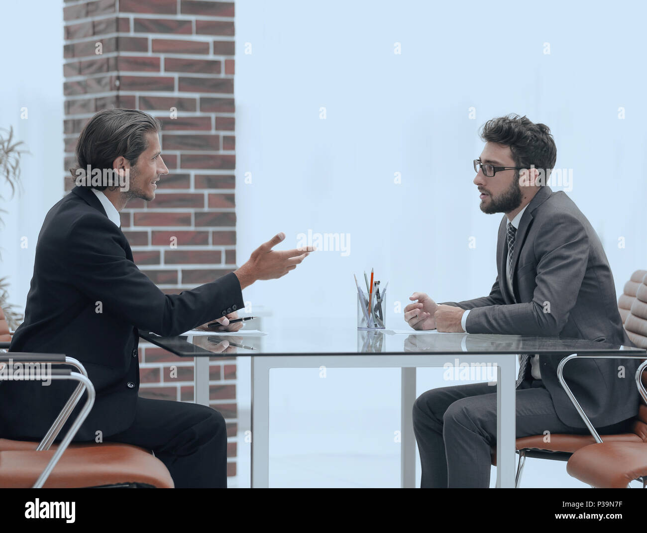 business partners talking while sitting at your Desk Stock Photo - Alamy