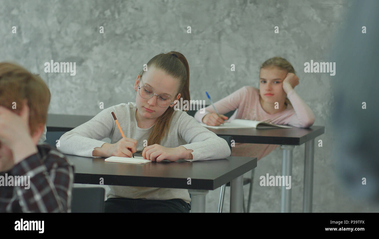 Students in school uniform taking exam at desk in a classroom Stock ...
