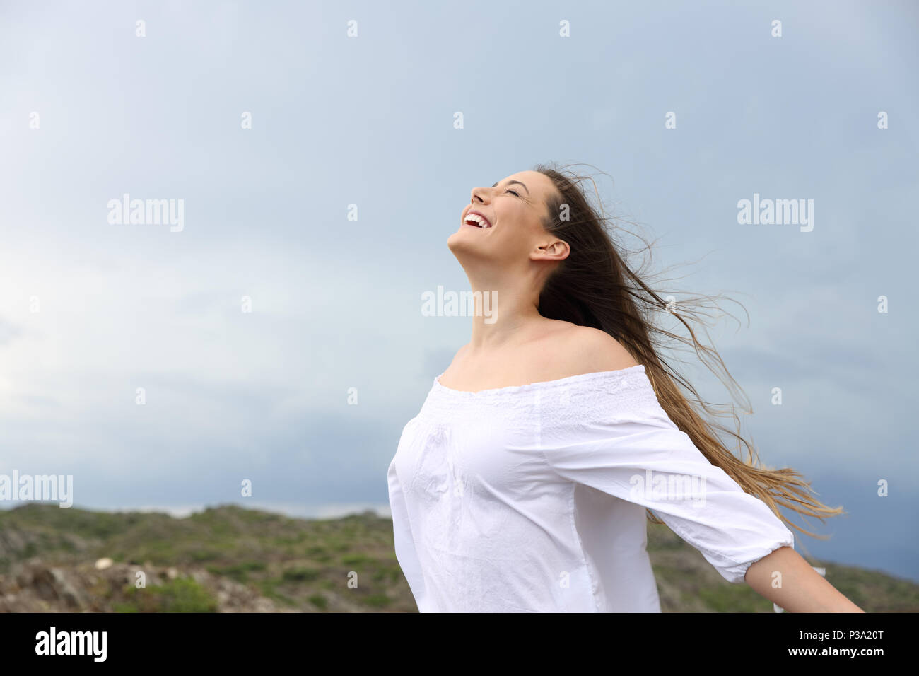 Positive woman breathing fresh air enjoying the wind Stock Photo - Alamy