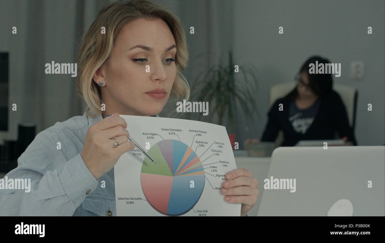 Office woman explaining pie chart to colleagues via laptop Stock Photo ...