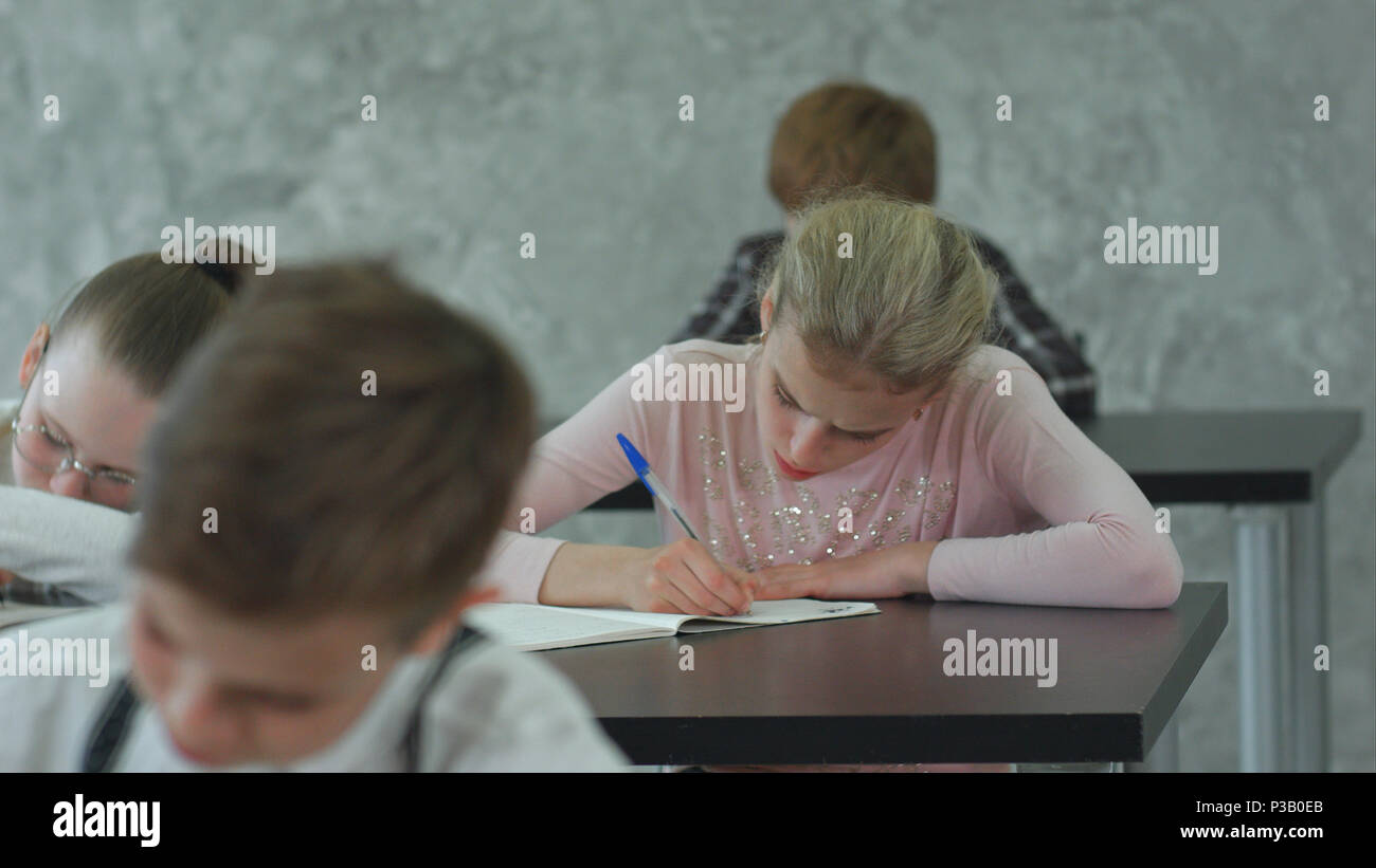 Group of students with notebooks writing test at school Stock Photo - Alamy