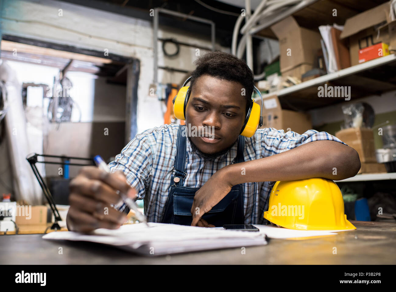 Thoughtful young engineer working in dark room Stock Photo - Alamy