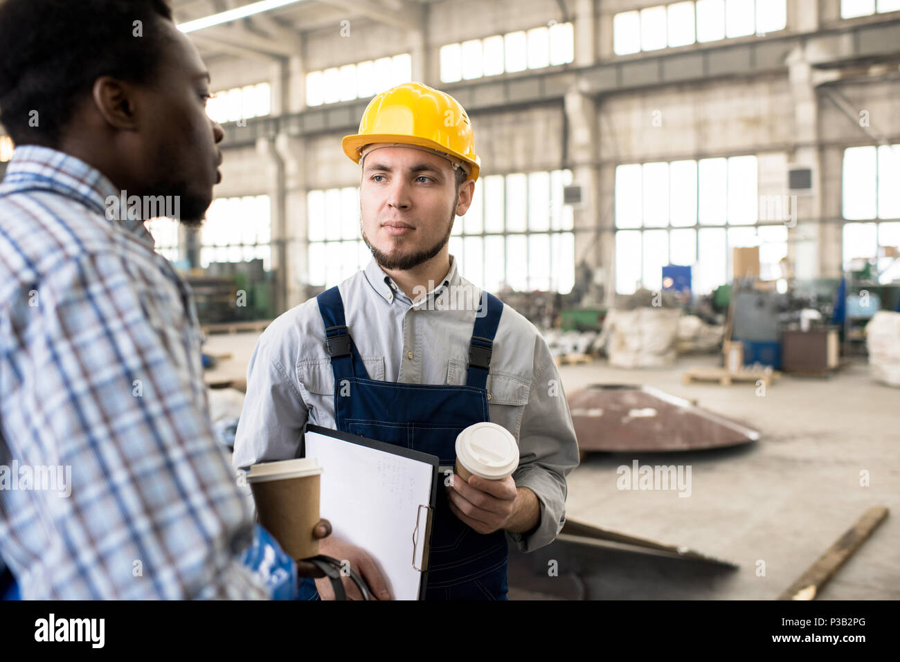 Serious construction colleagues making coffee break Stock Photo - Alamy
