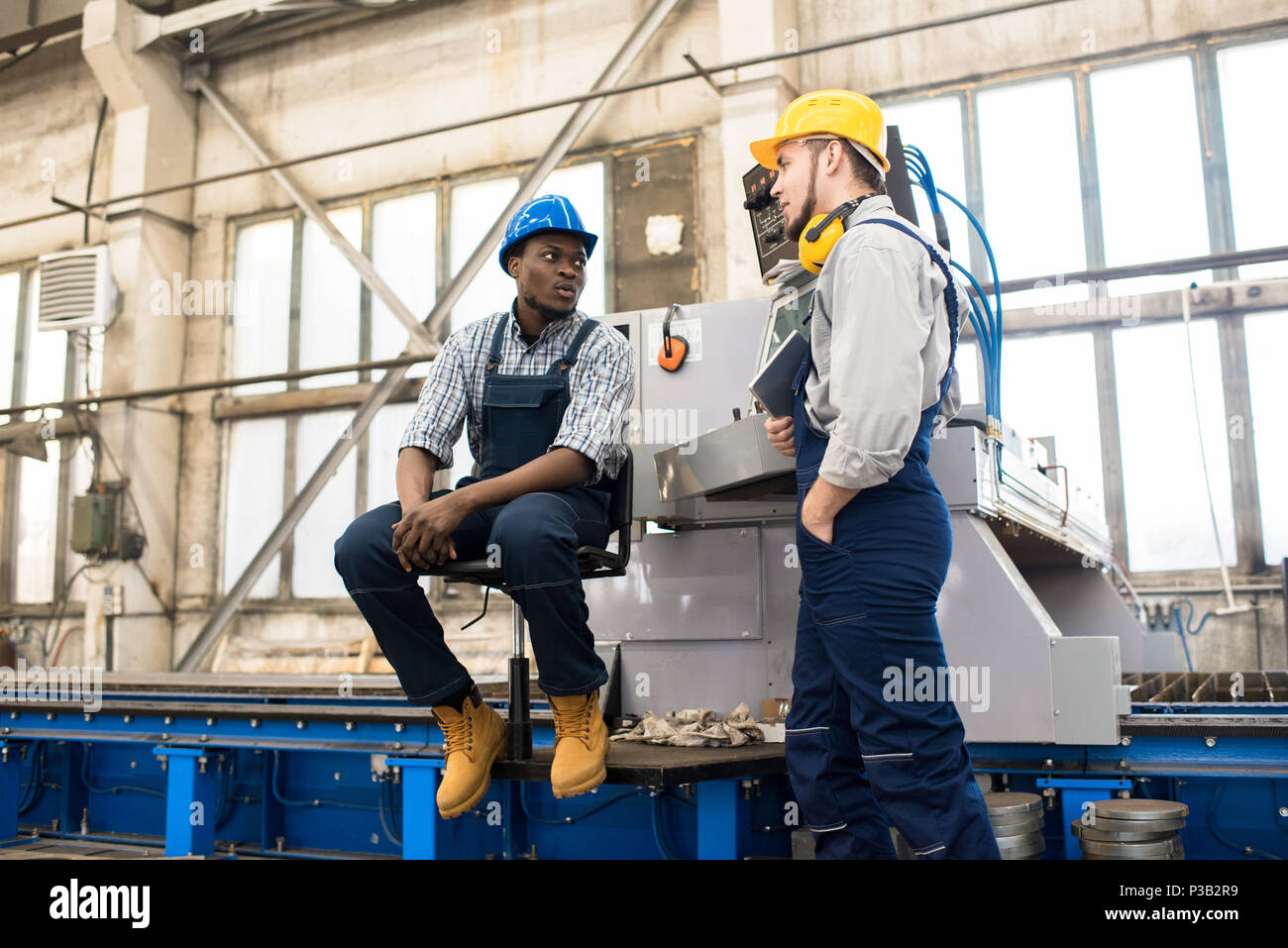 Multiethnic factory employees discussing work in shop Stock Photo - Alamy