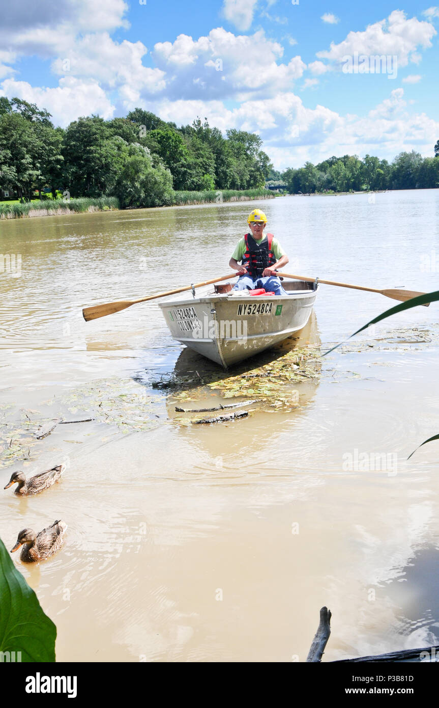Construction worker in a rowboat spotting work being done on bridge ...