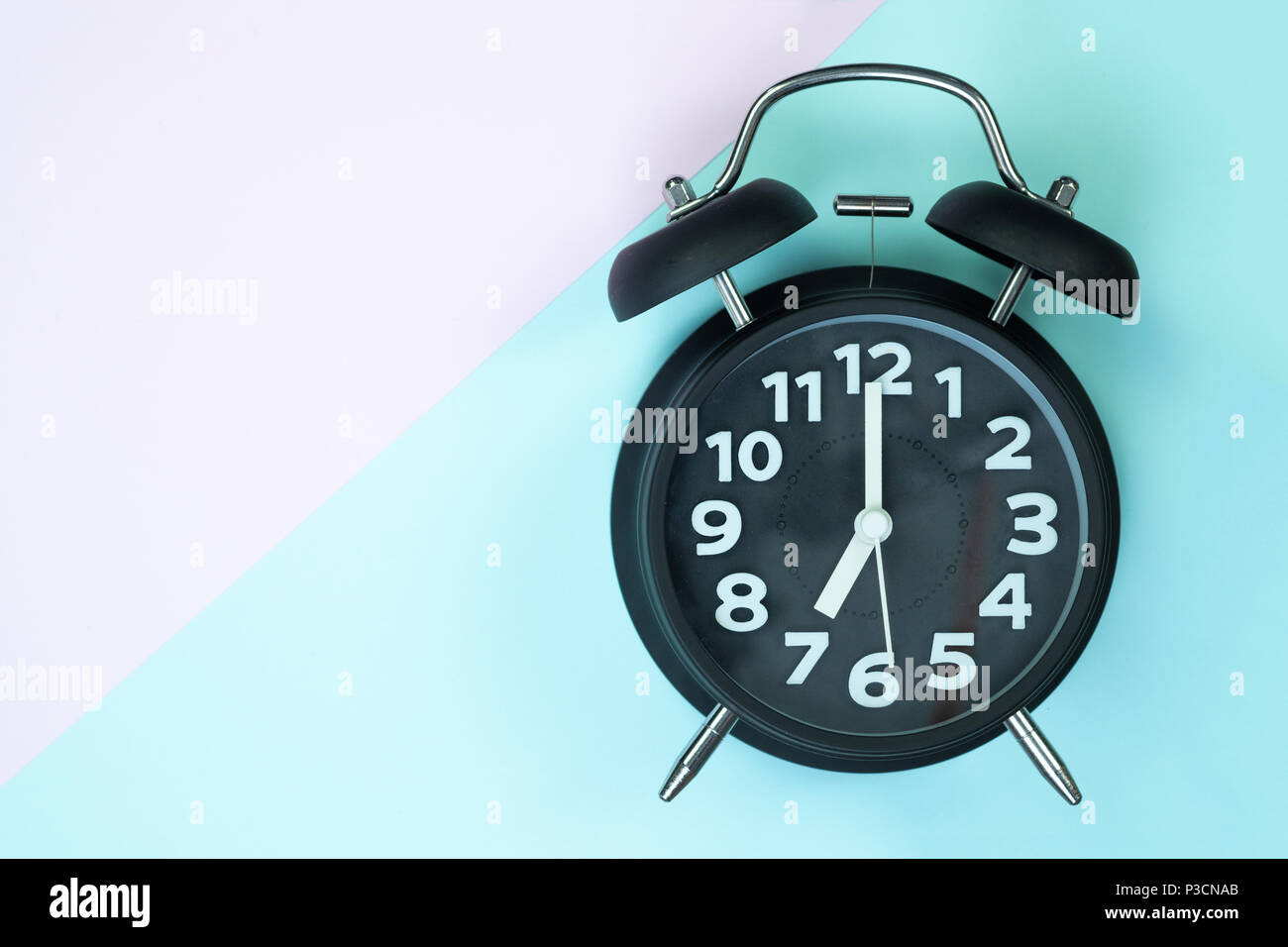 Flat lay vintage alarm clock on sweet pastel colored paper top view ...