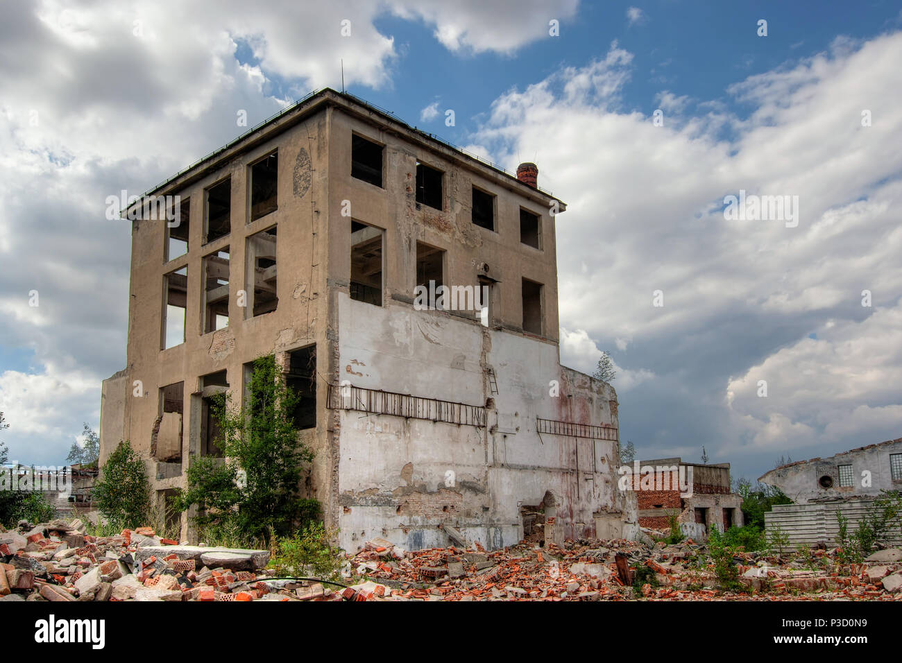 Ruins of abandoned and dilapidated factory overgrown of vegetation ...