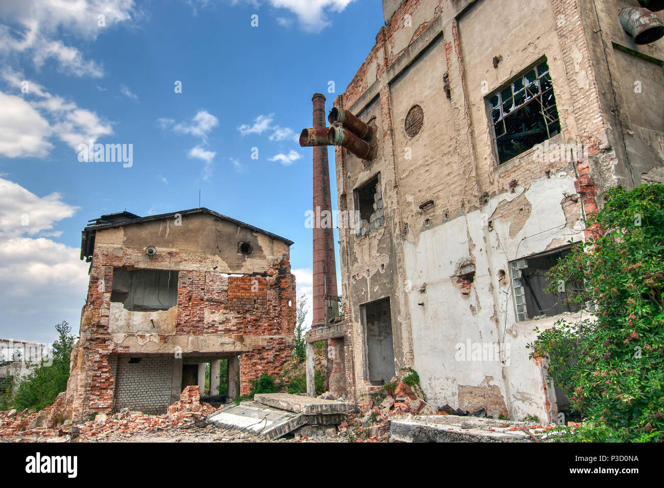 Ruins of abandoned and dilapidated factory overgrown of vegetation ...