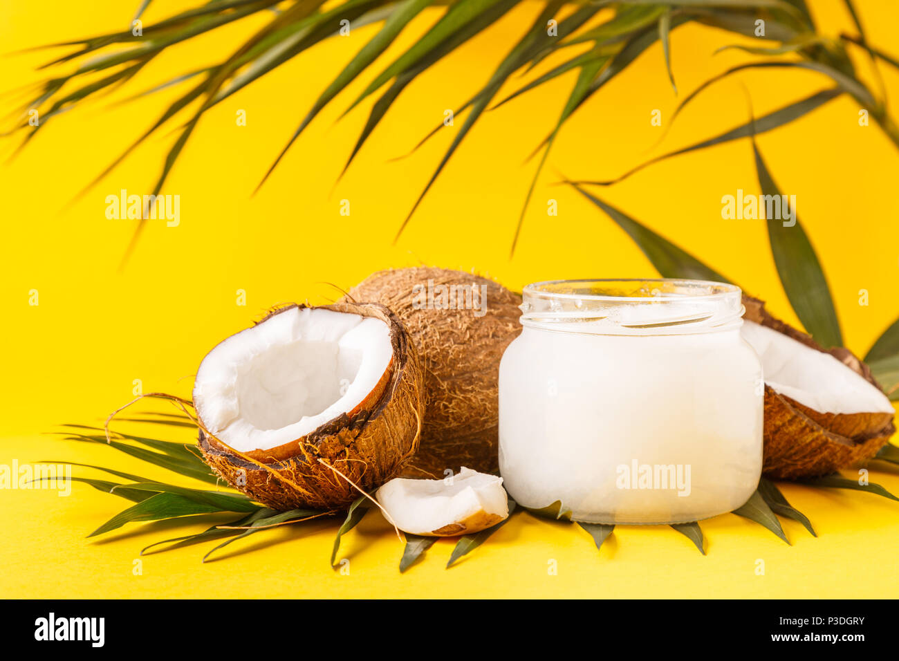 Coconut oil and coconuts on a bright pastel background, selective focus ...