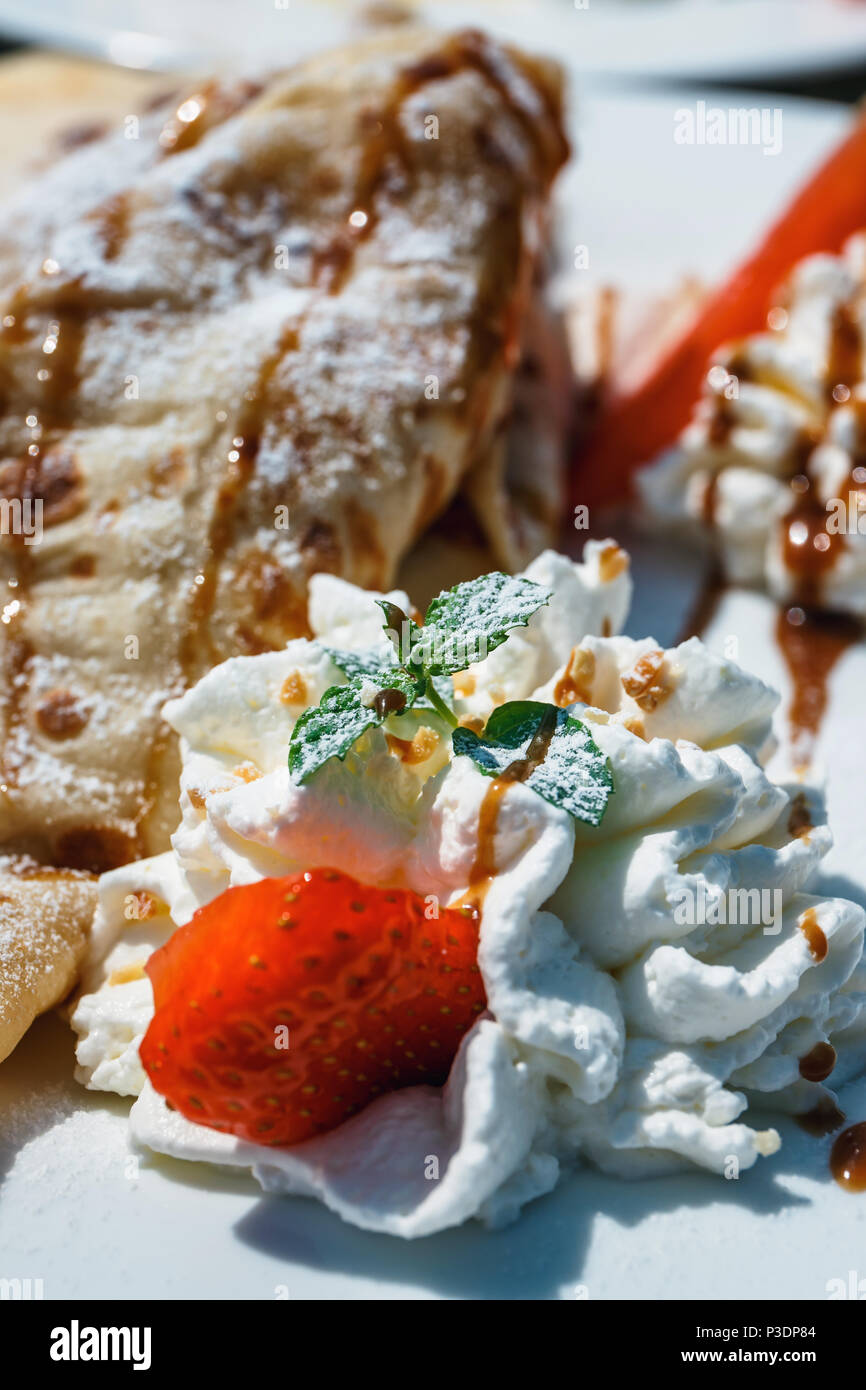 pancake with apple filling decorated with whipped cream, strawberries ...