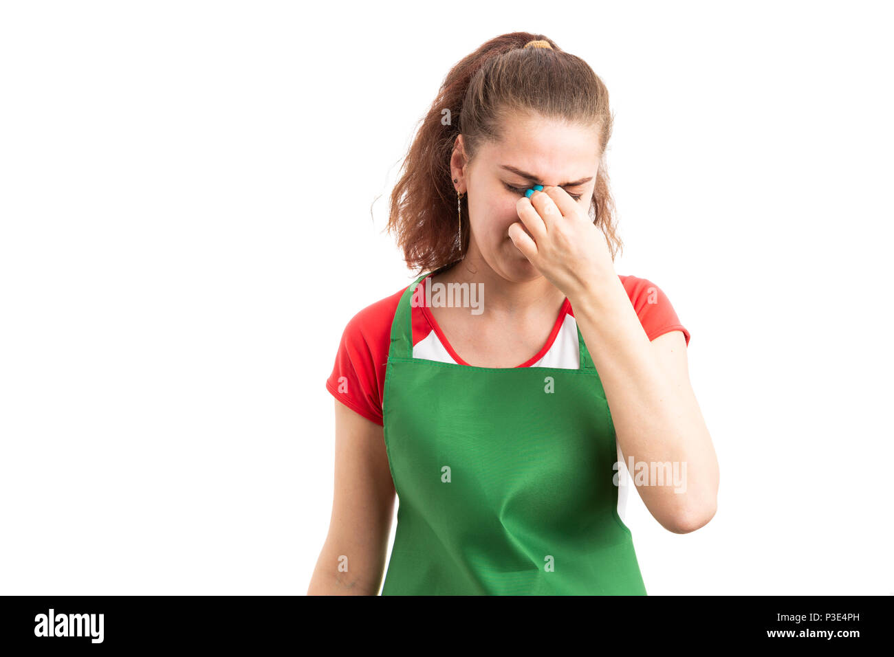 Young female retail storekeeper or worker suffering head pain as ...