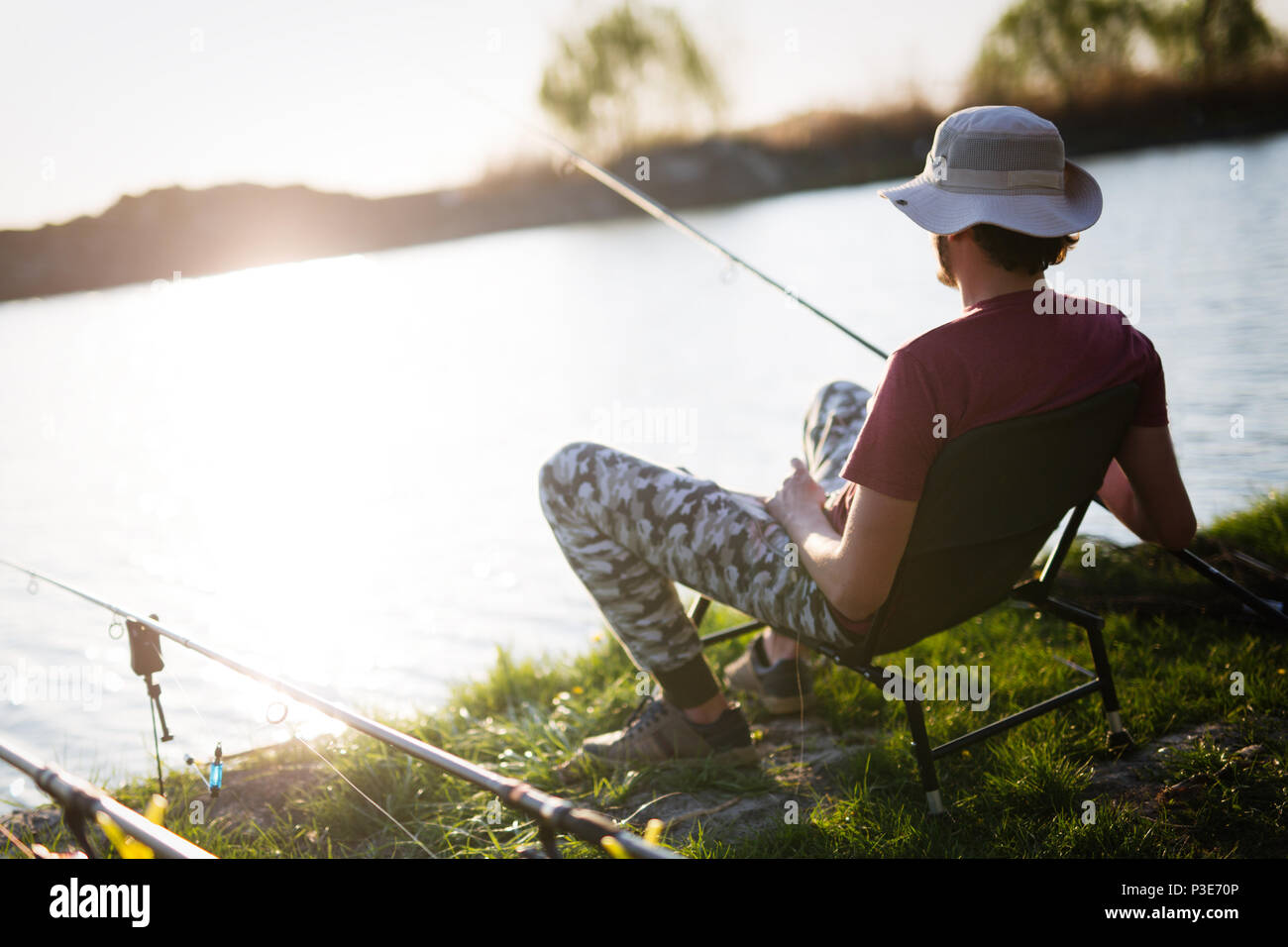 Men fishing in sunset and relaxing while enjoying hobby Stock Photo - Alamy