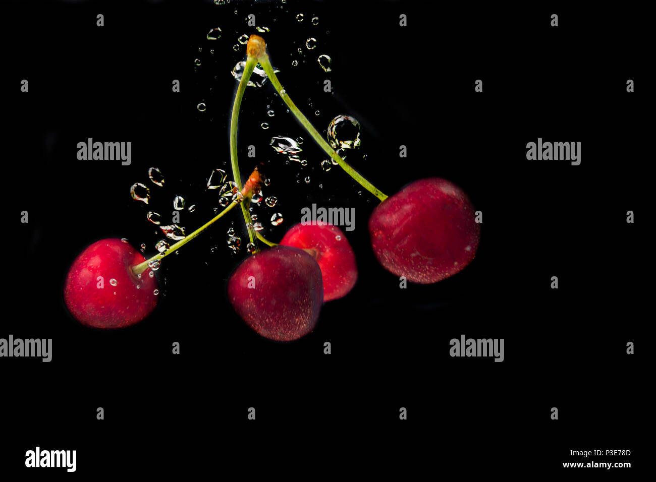 Red cherry falling into the water Stock Photo - Alamy