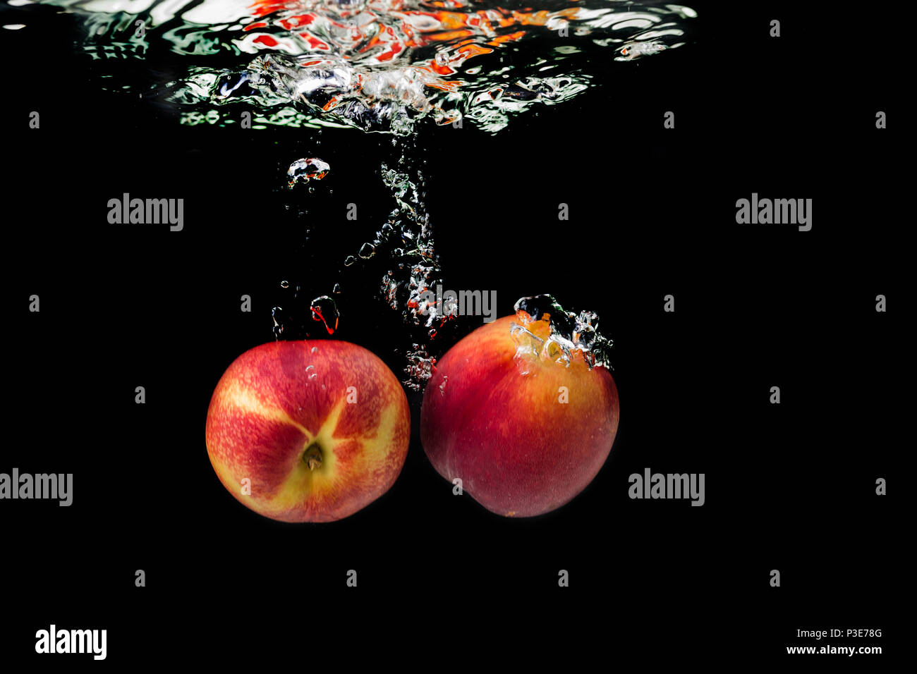 Peach drop into the water Stock Photo - Alamy