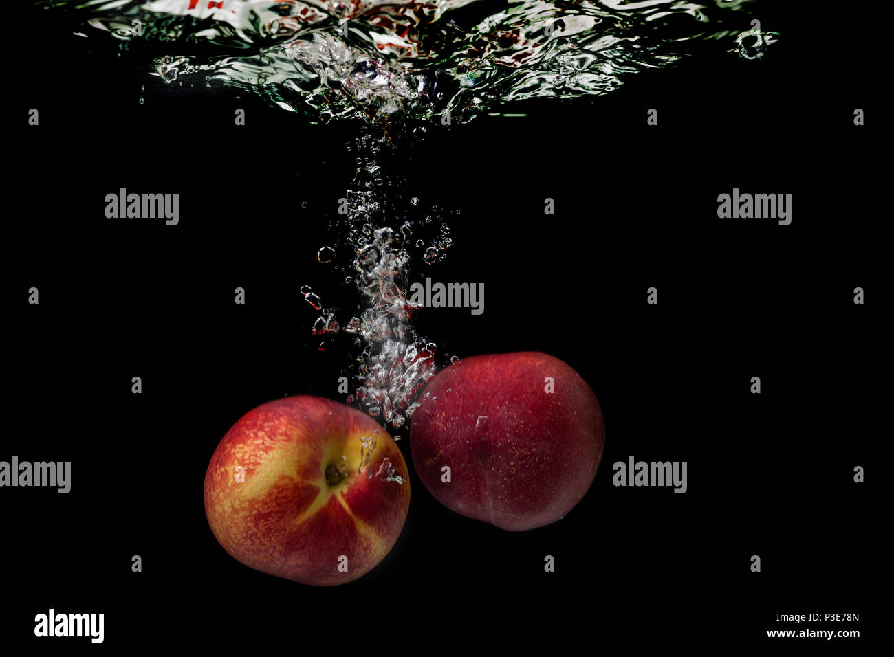 Peach drop into the water Stock Photo - Alamy