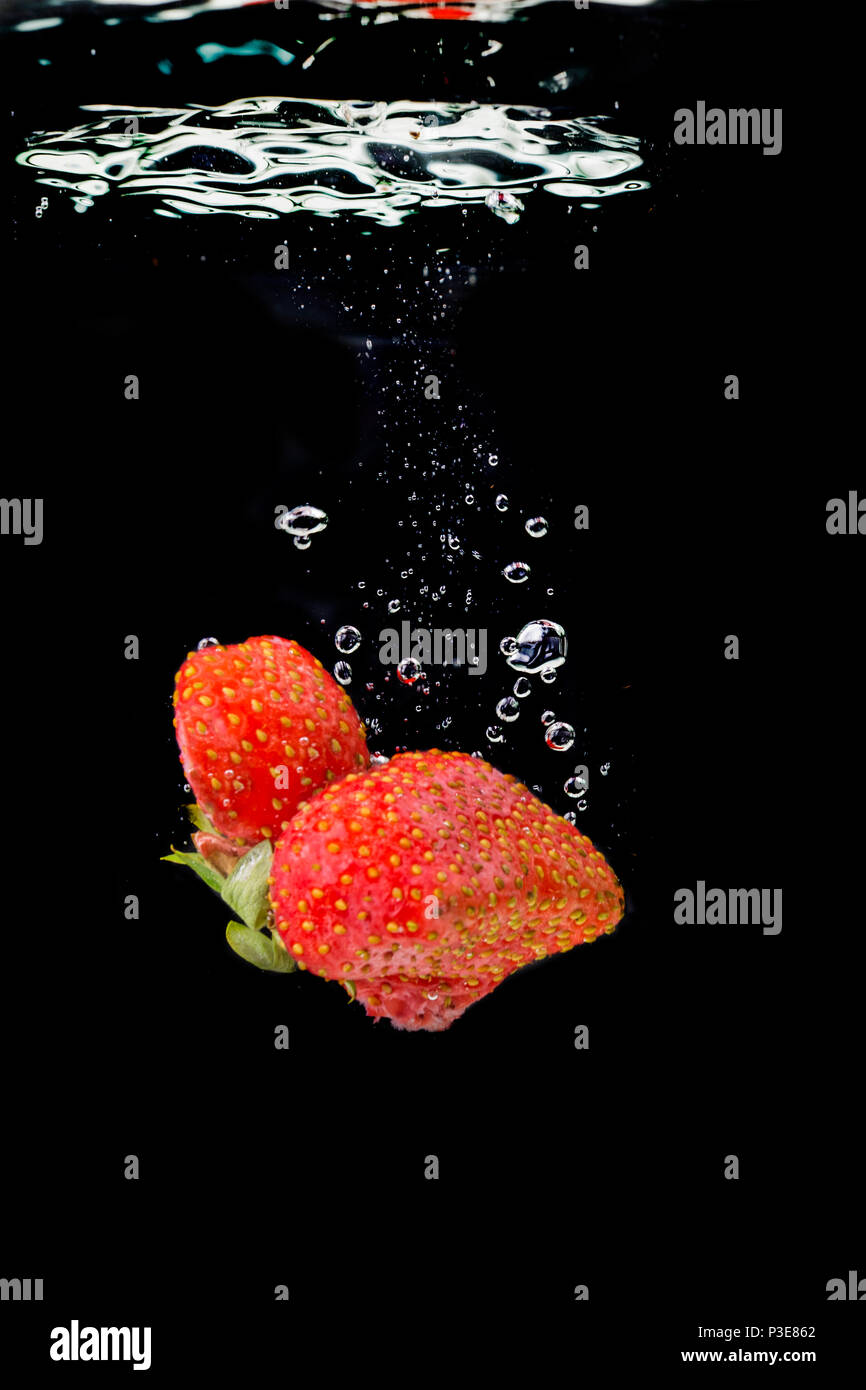 Red strawberry falling into water Stock Photo - Alamy
