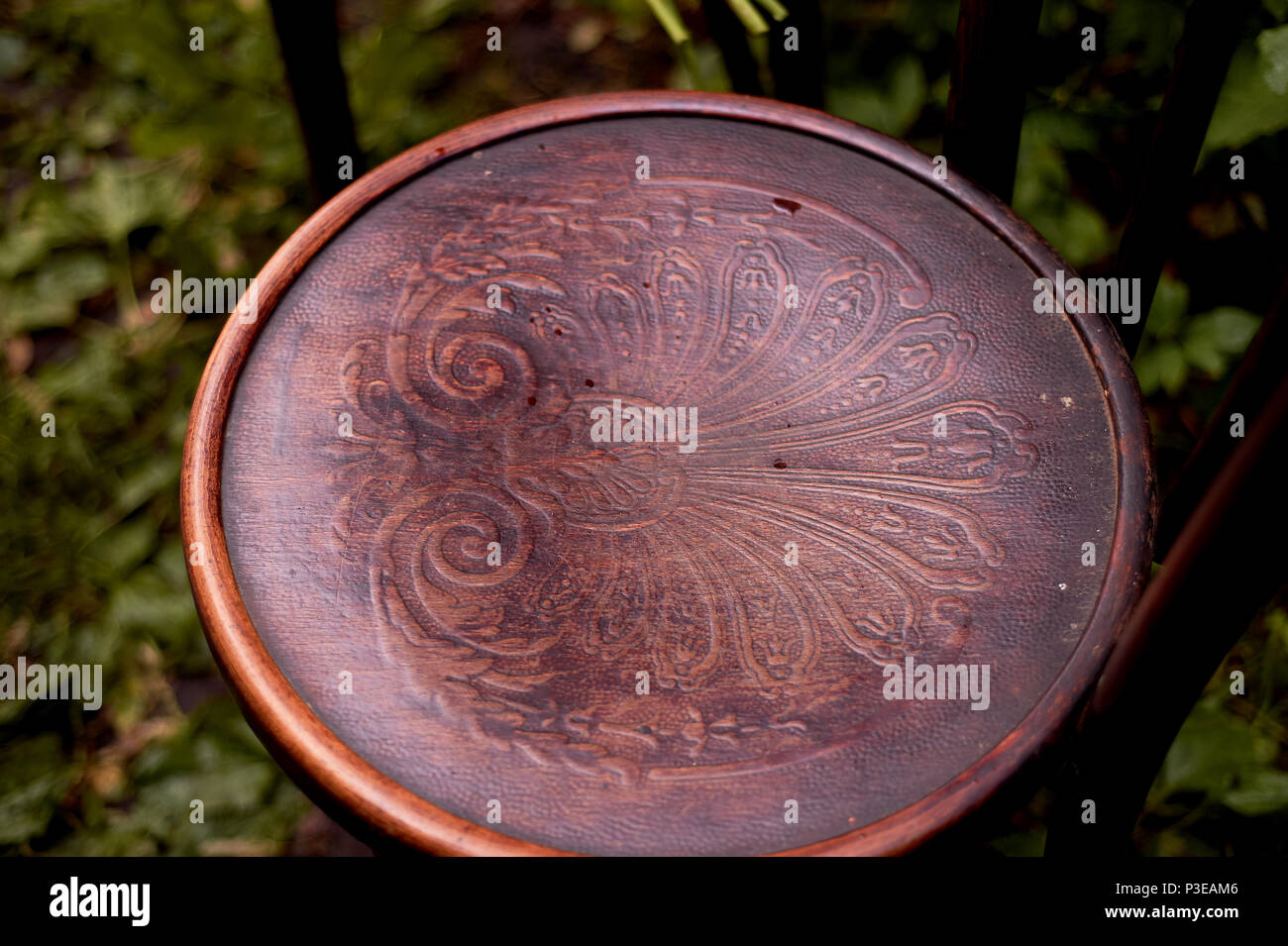 the seat of an old carved chair made of wood. Carving and dark toning ...
