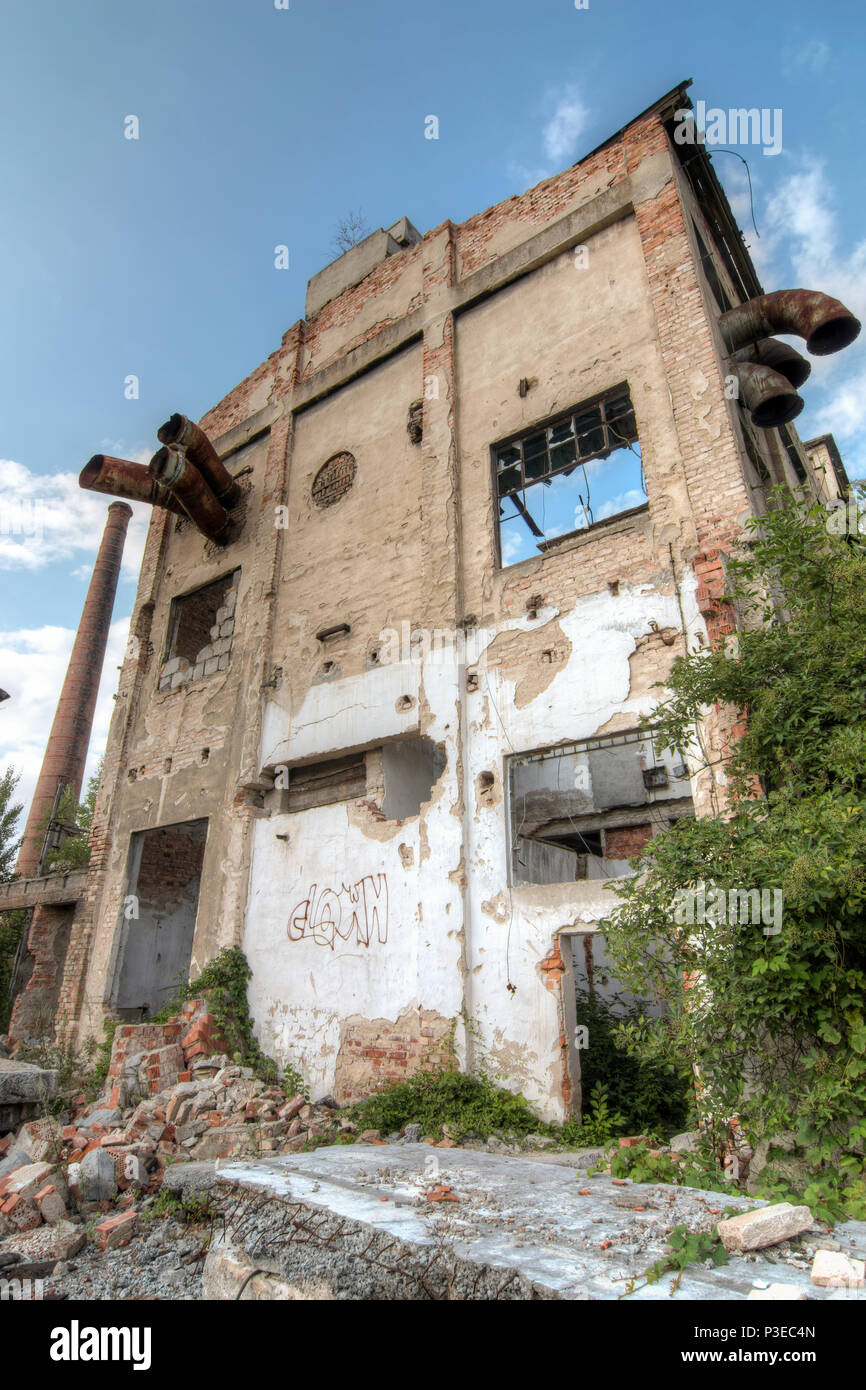 Ruins of abandoned and dilapidated factory overgrown of vegetation ...