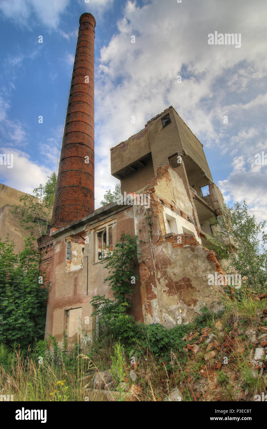 Ruins of abandoned and dilapidated factory overgrown of vegetation ...