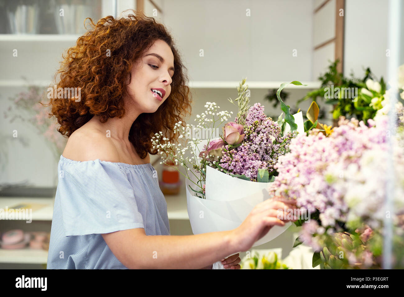 Nice pleasant woman touching flowers Stock Photo - Alamy
