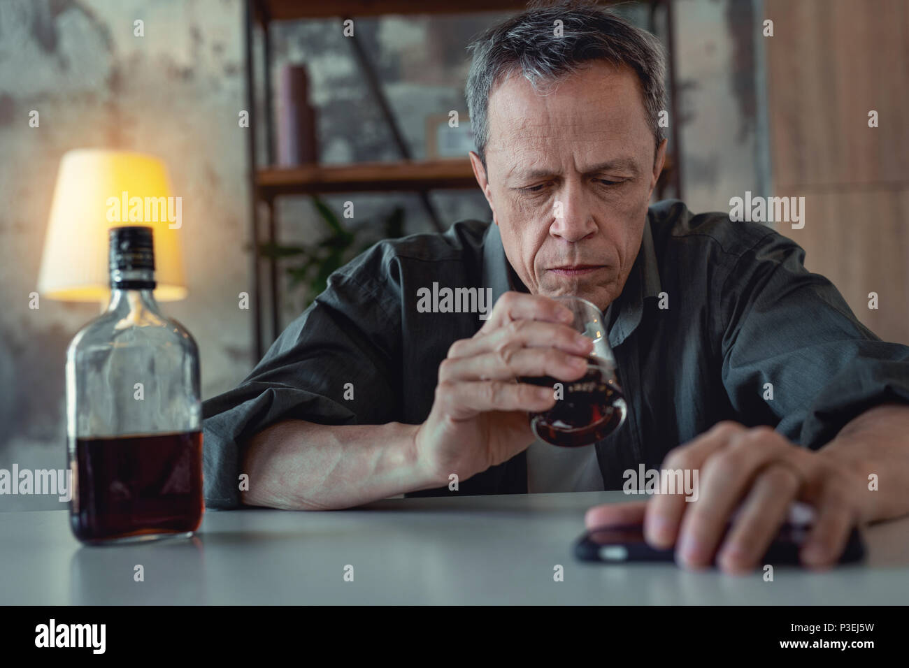 Grey-haired man feeling in despair suffering from alcohol addiction ...