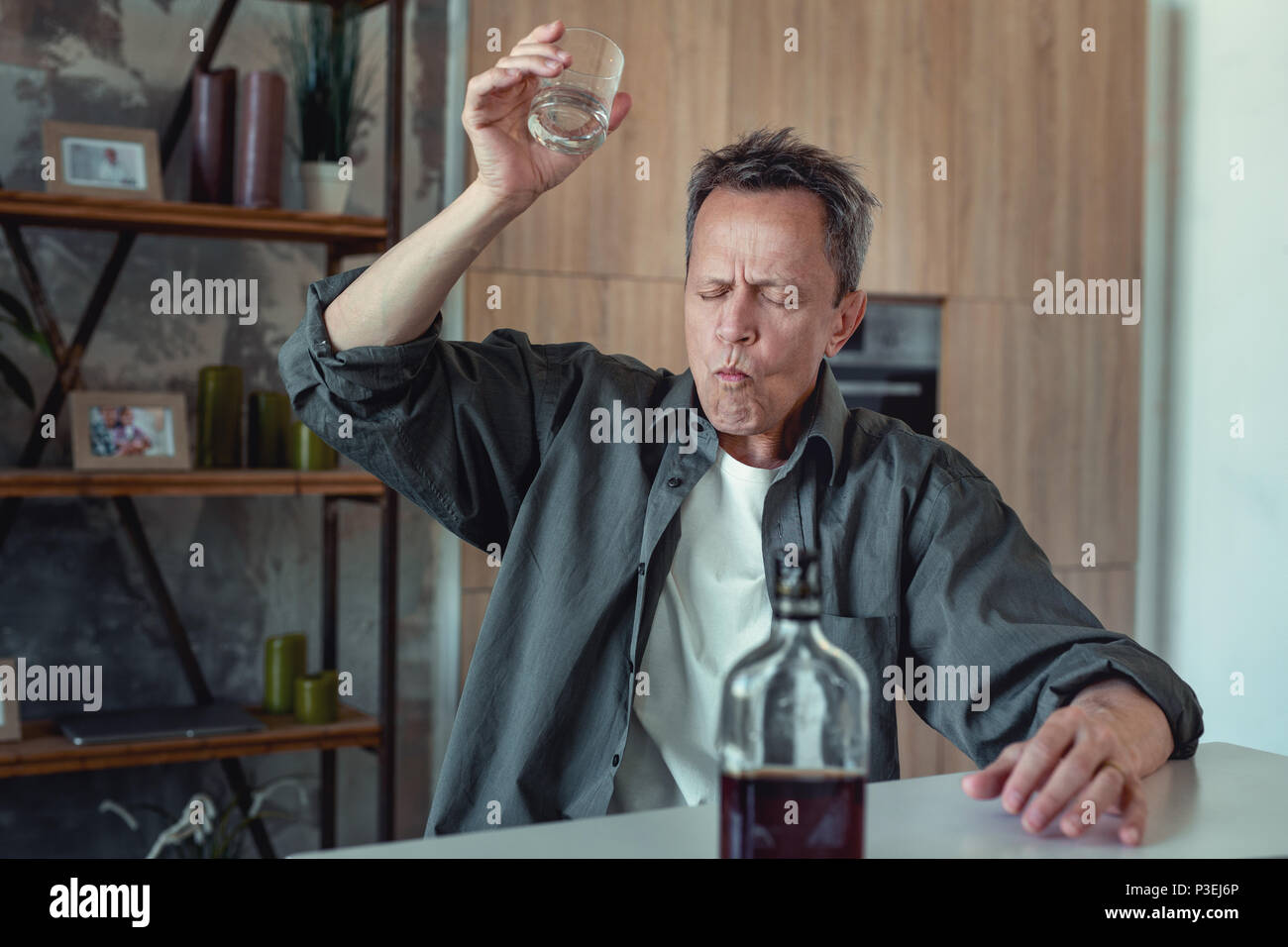 Grey-haired alcoholic finishing glass of whisky after awful day Stock ...