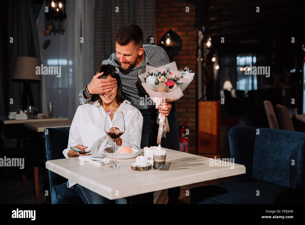 attractive young woman getting a flowers from her boyfriend while ...
