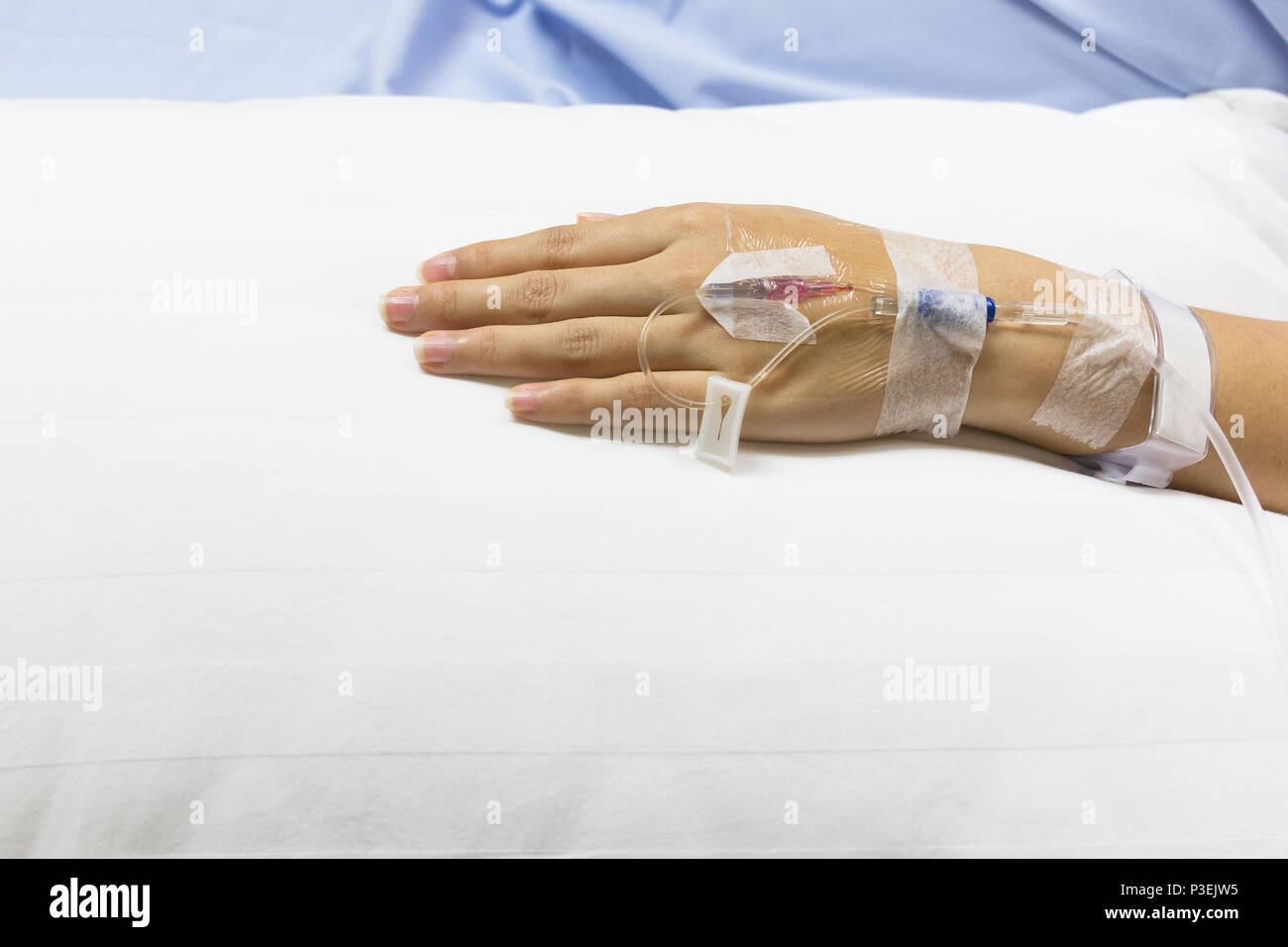 Asian woman patient is on drip receiving a saline solution on bed VIP ...