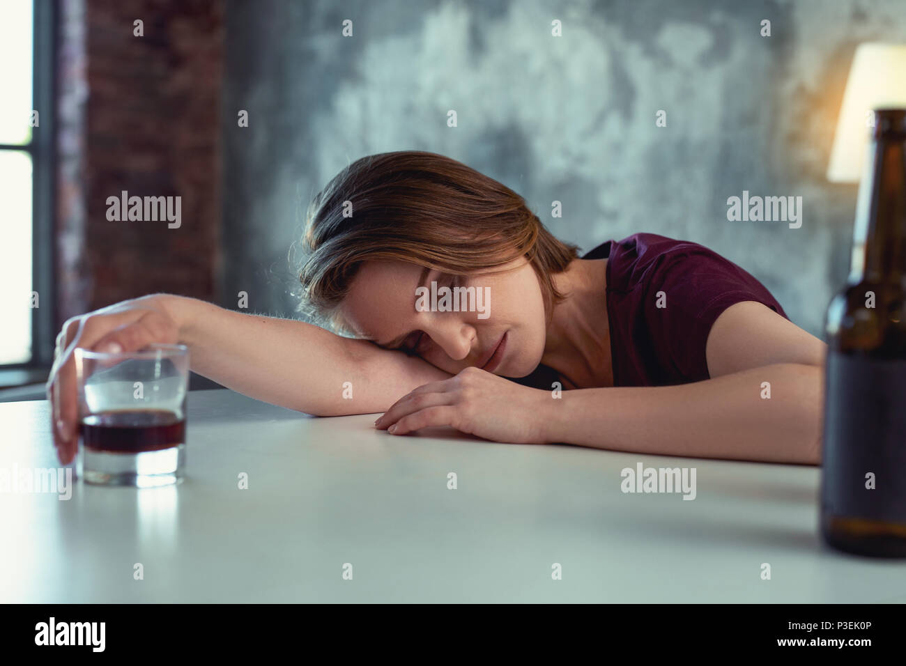 Drunk addicted woman falling asleep at the table Stock Photo - Alamy