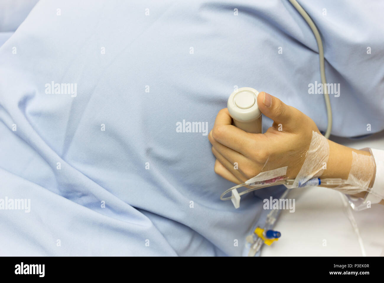 Asian Pregnant Woman patient is on drip receiving a saline solution and ...