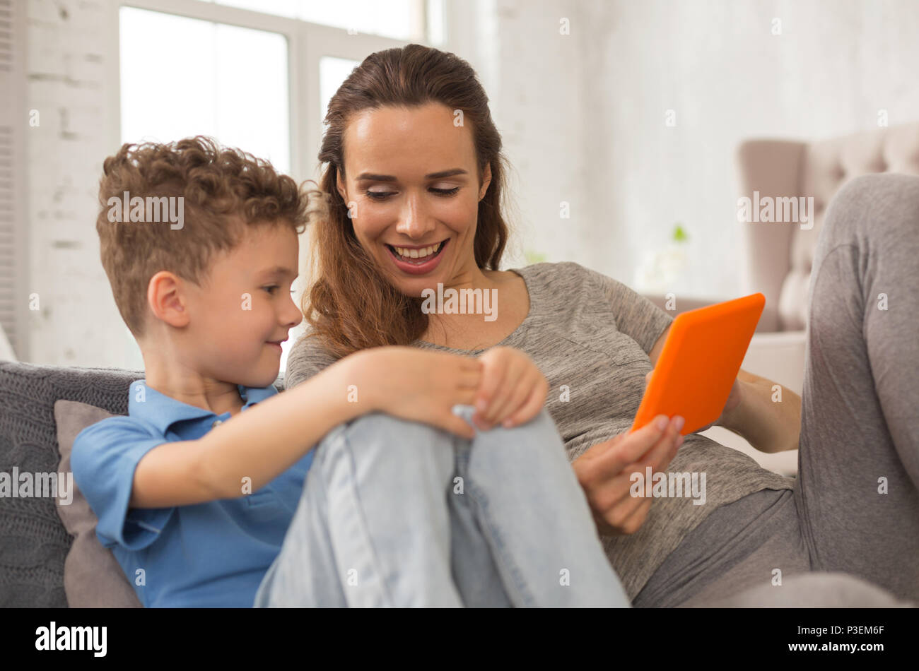 Laughing mother smiling broadly while telling jokes Stock Photo - Alamy