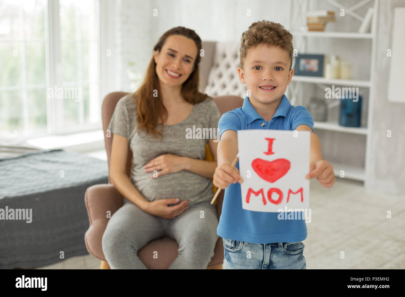 Loving little smart son painting picture for his pregnant mother Stock ...
