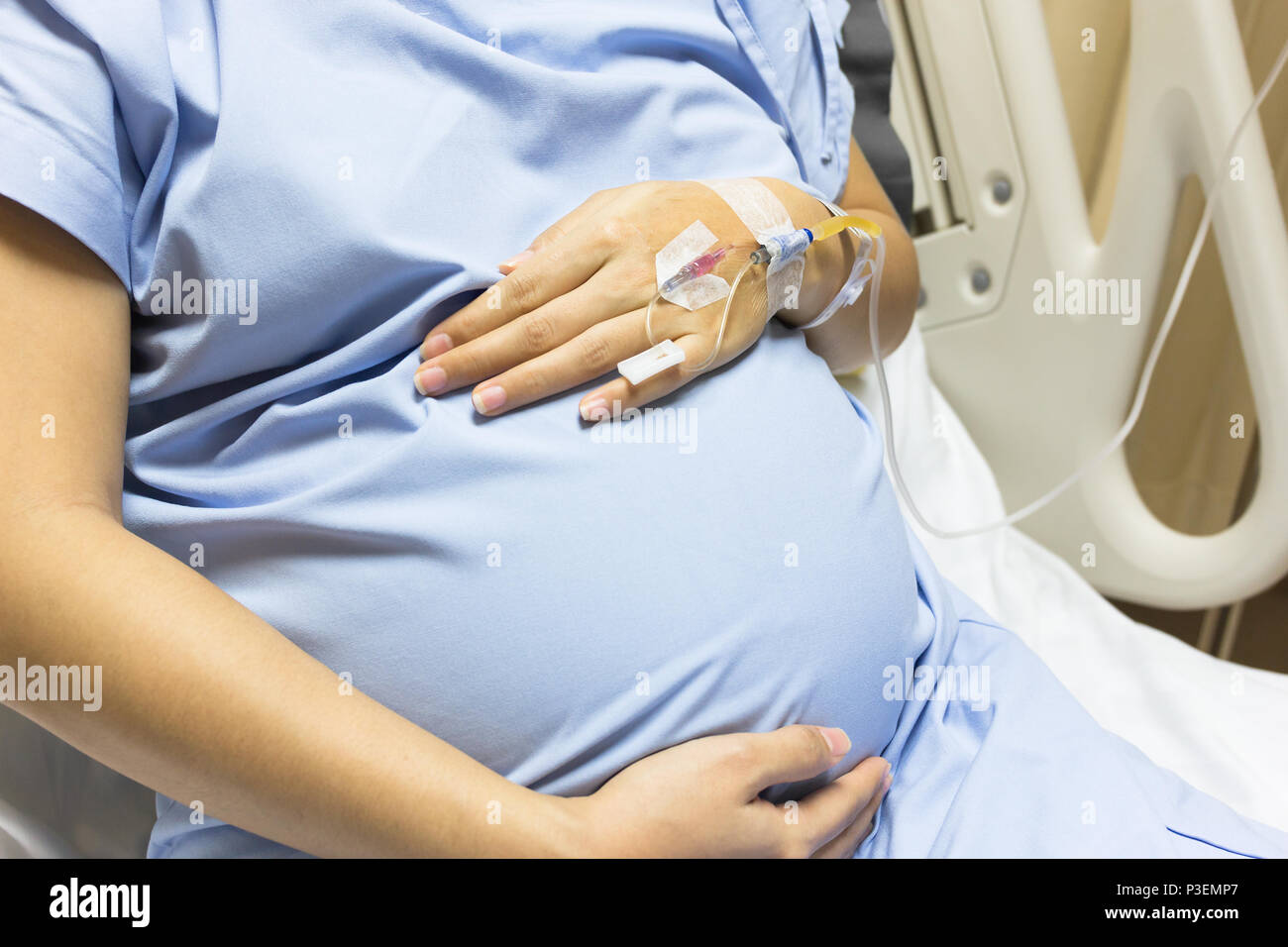 Asian Pregnant Woman patient is on drip receiving a saline solution on ...