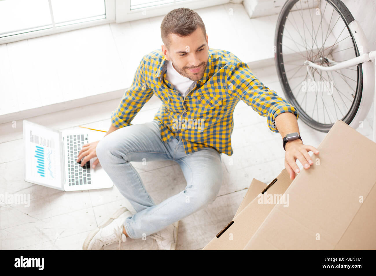 Glad bearded man counting boxes Stock Photo - Alamy