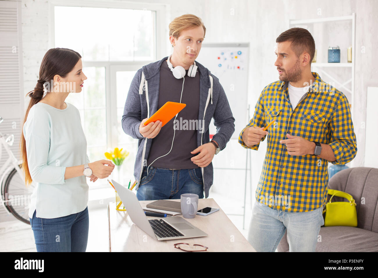 Focused three colleagues helping company Stock Photo - Alamy