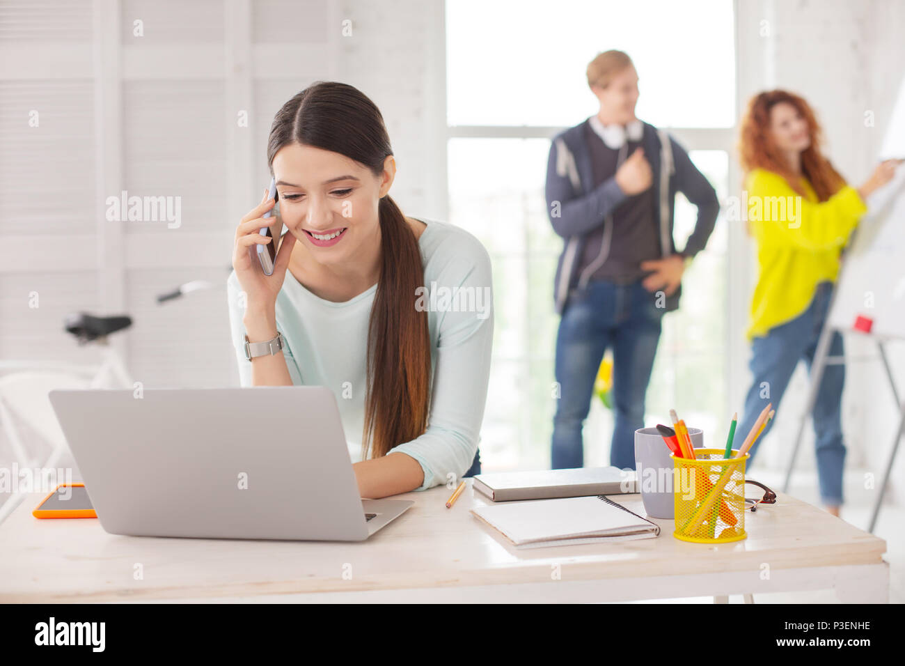 Charming female employee making call Stock Photo - Alamy