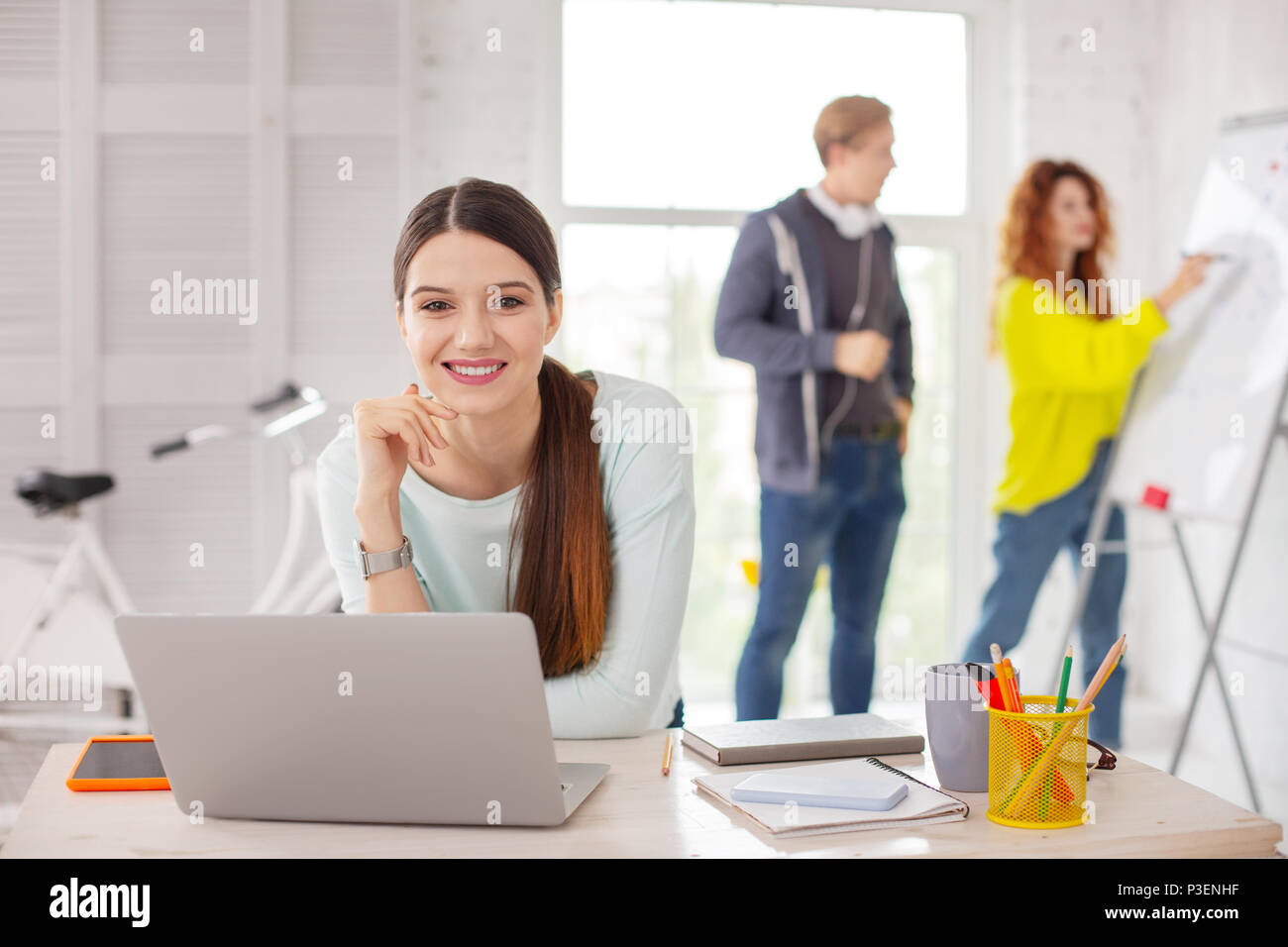 Happy female employee getting ready to work Stock Photo - Alamy