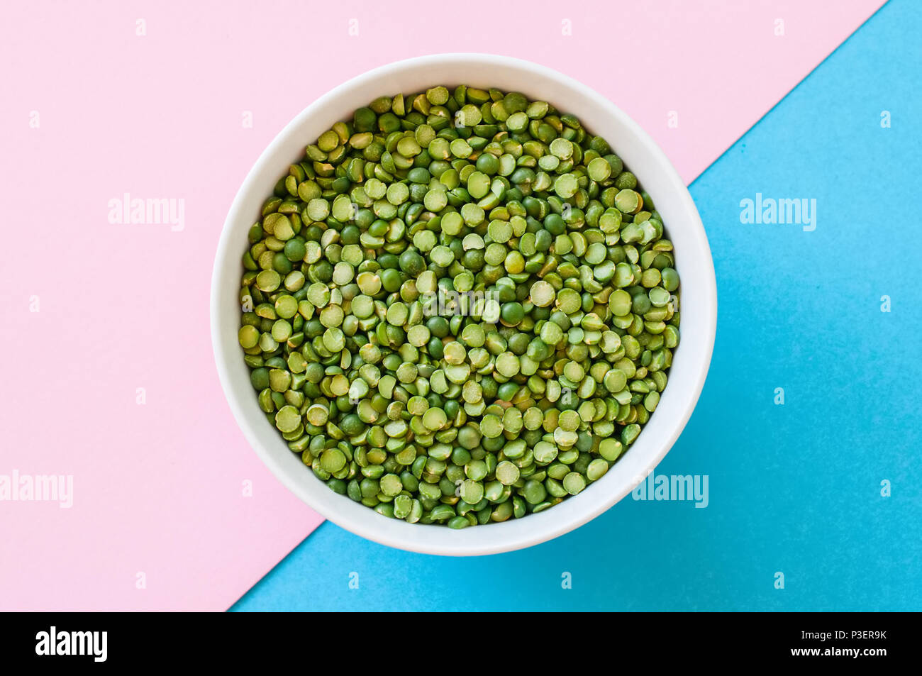 Raw uncooked green peas in a white bowl on duotone background. Top view ...