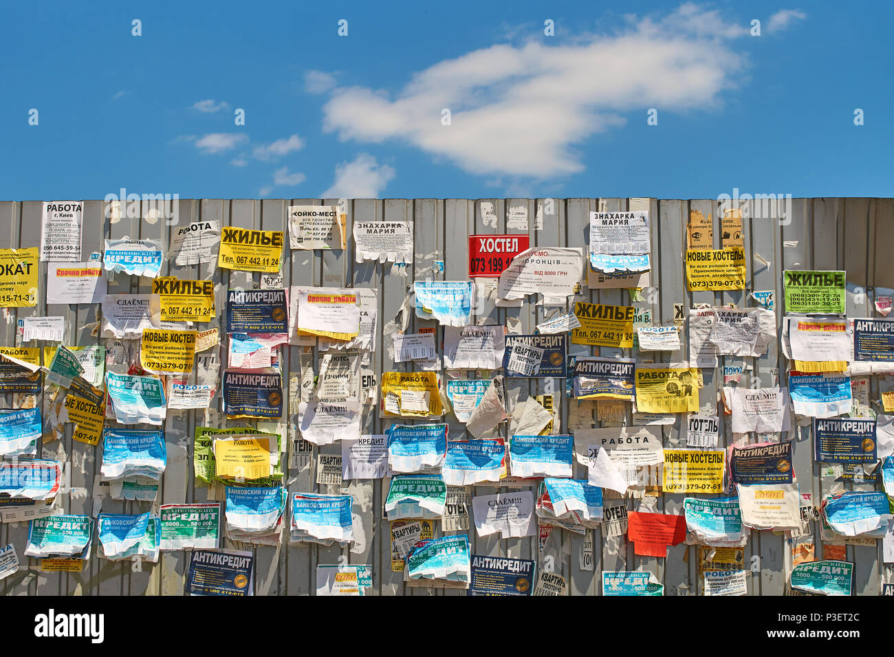 Bulletin board on the metal fence with colourful messages on the street ...